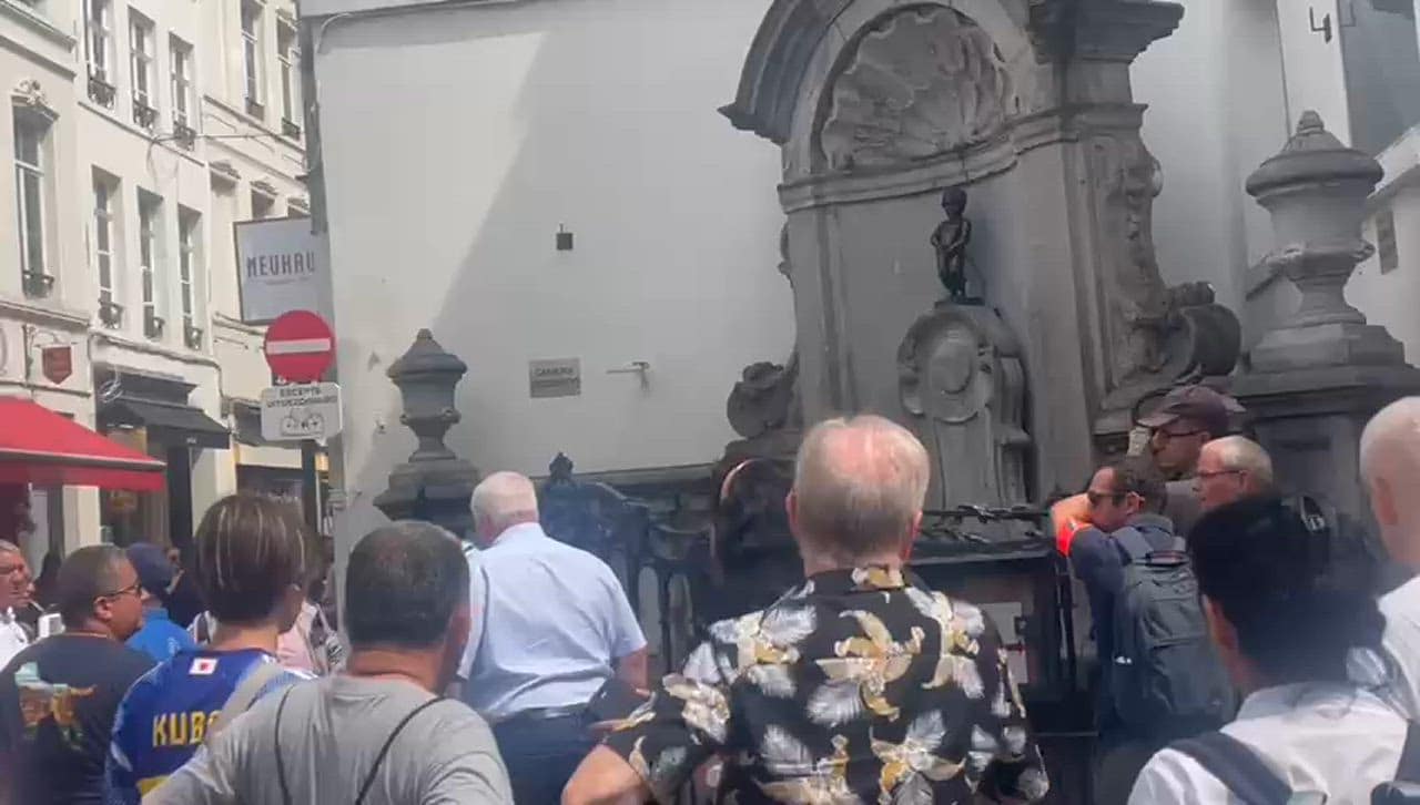 Activist Wouter Mouton probeert hek bij Manneken Pis te beklimmen ...